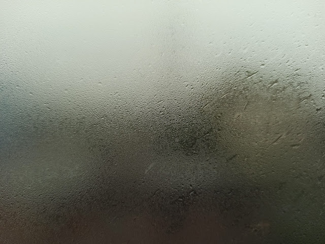 Water molecules gather on the surface of a glass window in a rainy day ...