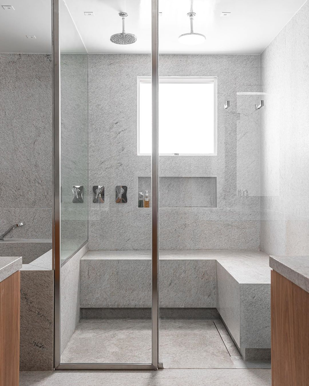 Banheiro com banheira todo revestido em granito siena escovado e ...