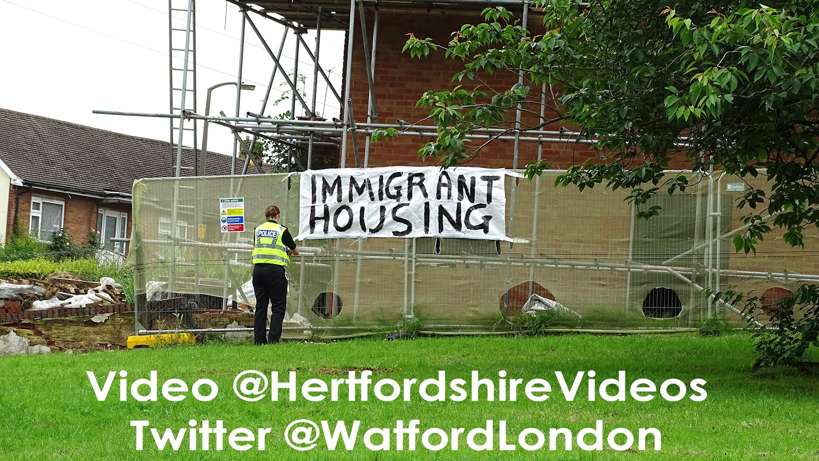 Police at House with Immigrant Housing Graffiti Banner - Wat News