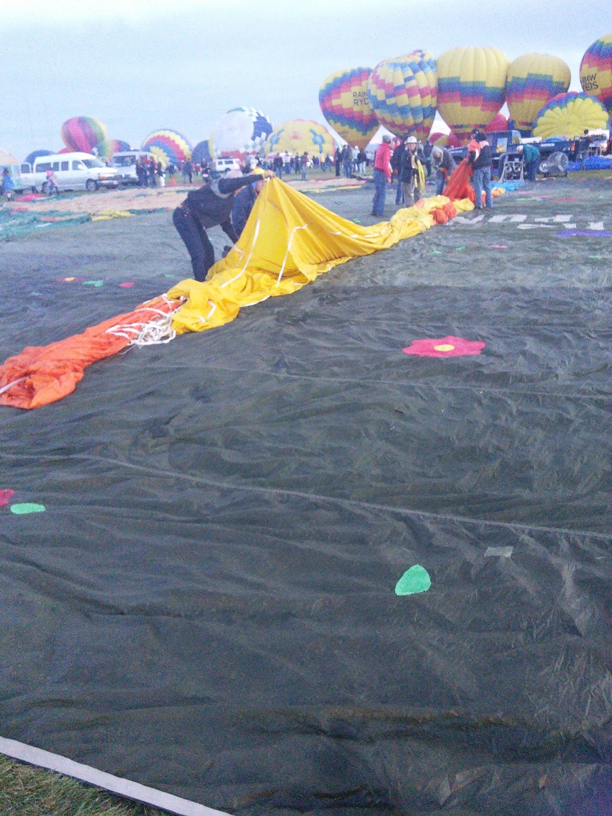 The sun begins to come out and the pilots lay out their balloons and ...