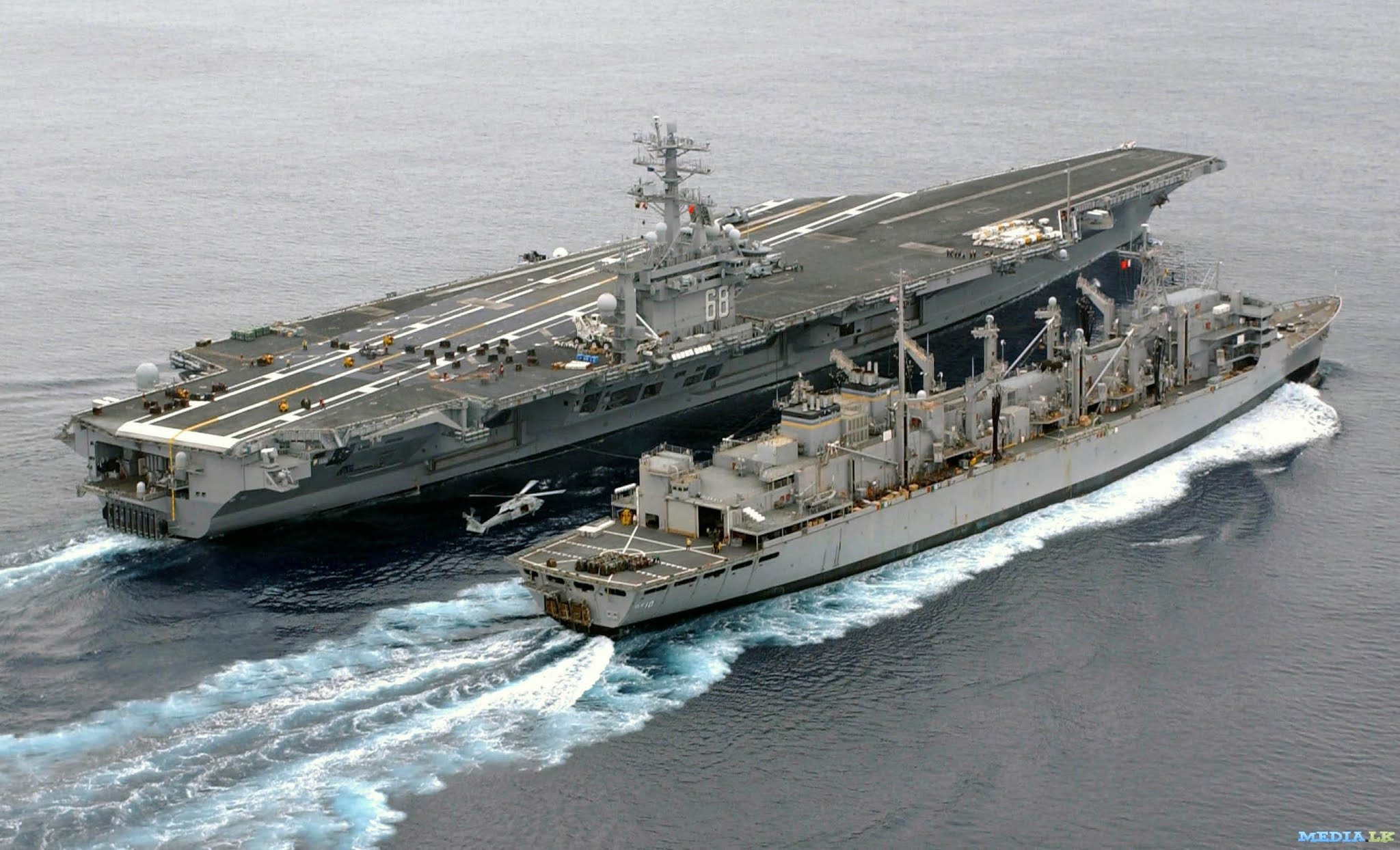 The nuclear-powered aircraft carriers USS Nimitz (CVN 68) sails along ...