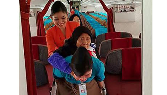 Garuda Indonesia flight attendant uniforms Passengers holding the ...