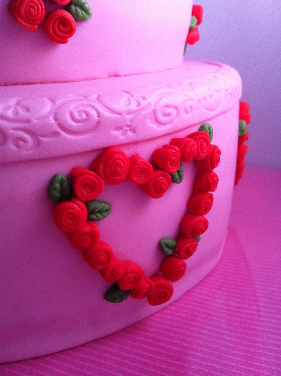 Taart bij Essy's Cosy-Cakes: roze taart met rode rol roosjes