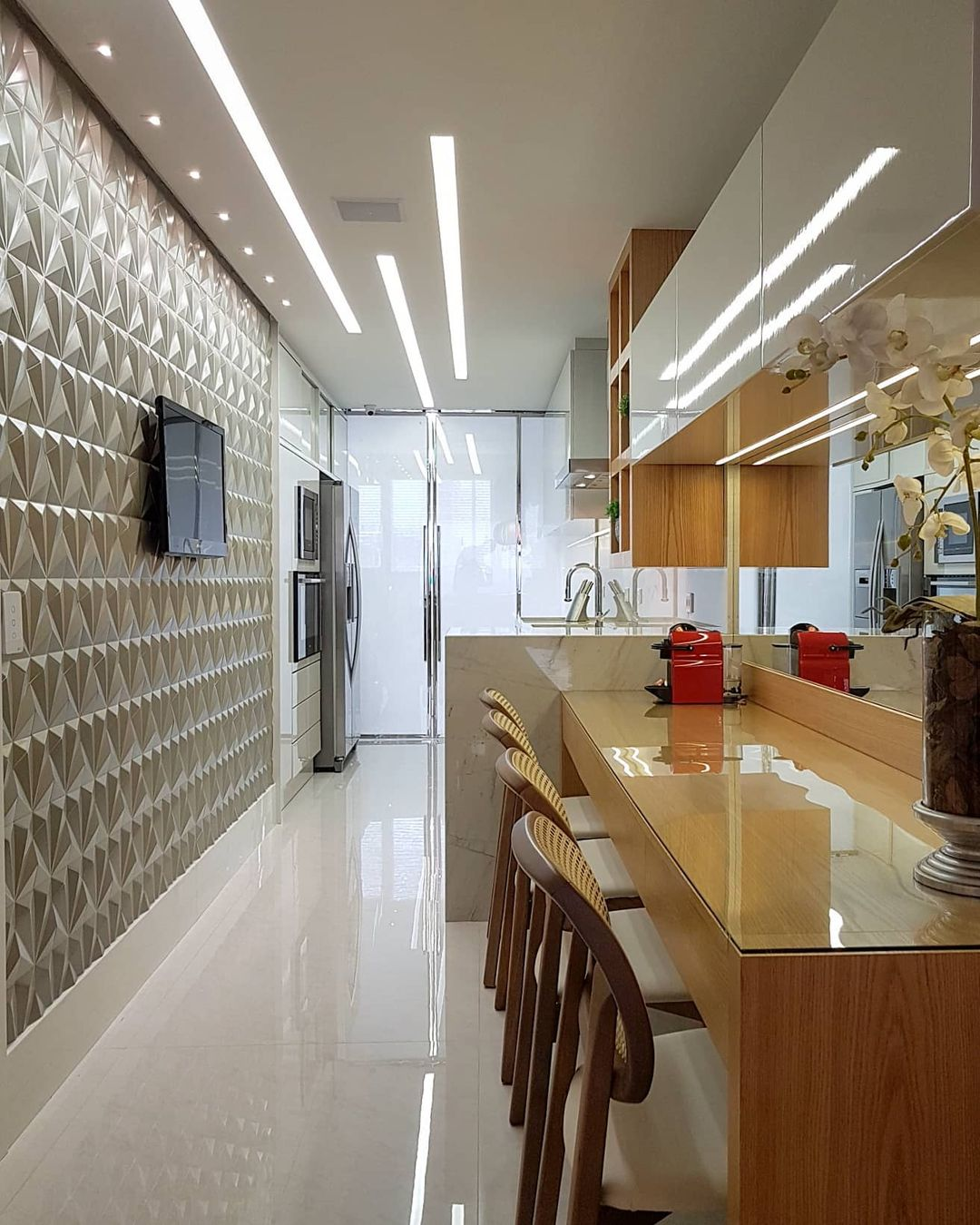 Cozinha estreita em porcelanato branca e amadeirada com ilha e parede ...