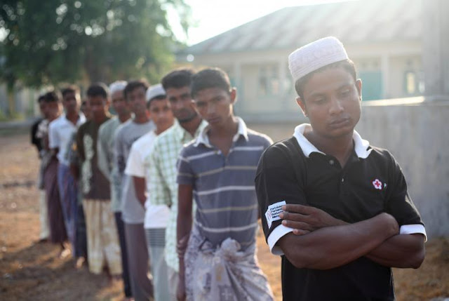 Rohingya Muslims wait in line for breakfast in Aceh