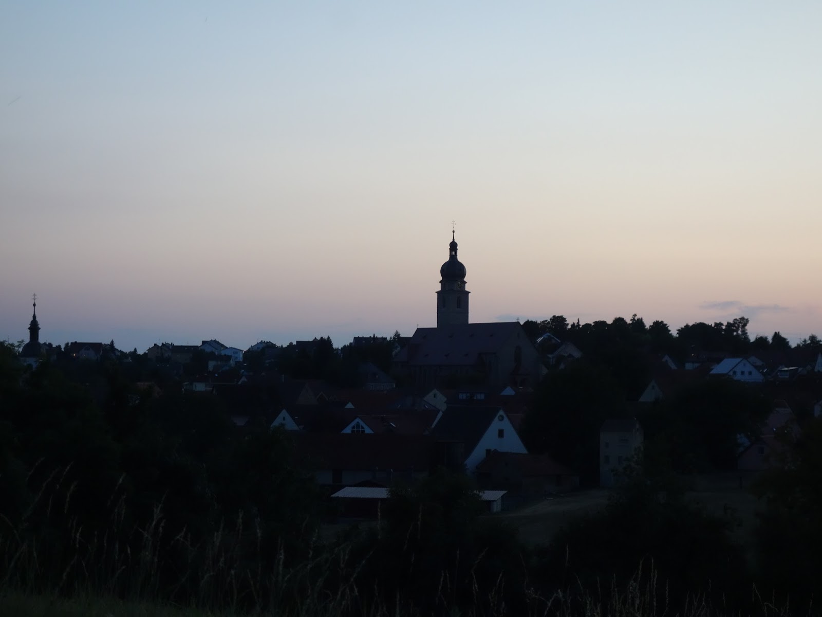 Unterfrankes Welt: Silhouette der Gemeinde Estenfeld in der Abenddämmerung