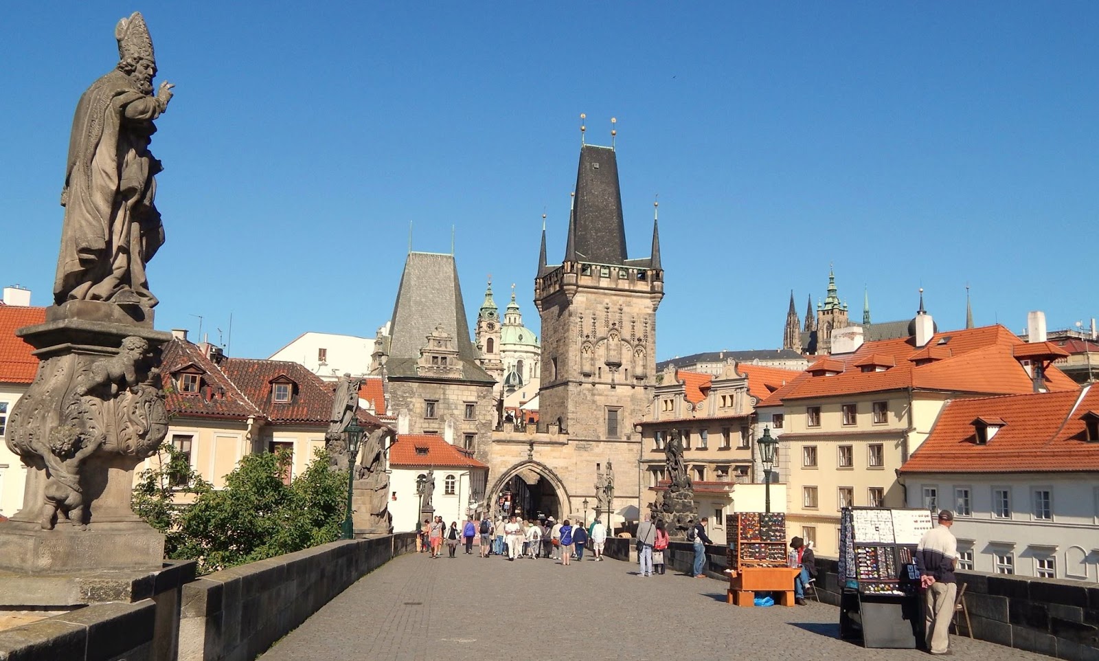 MĚSTO PRAHA: Prague. Praha Karlův most ráno. Turisté přicházejí...
