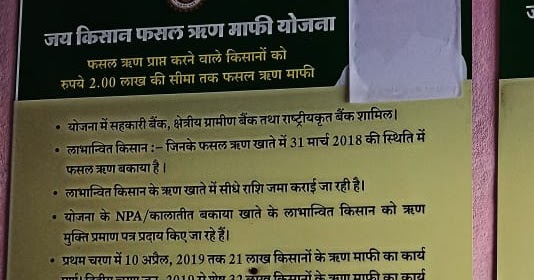 फसल ऋण माफी योजना के होर्डिग्स पर मुख्यमंत्री फ़ोटो पर कागज चिपकाने को ...