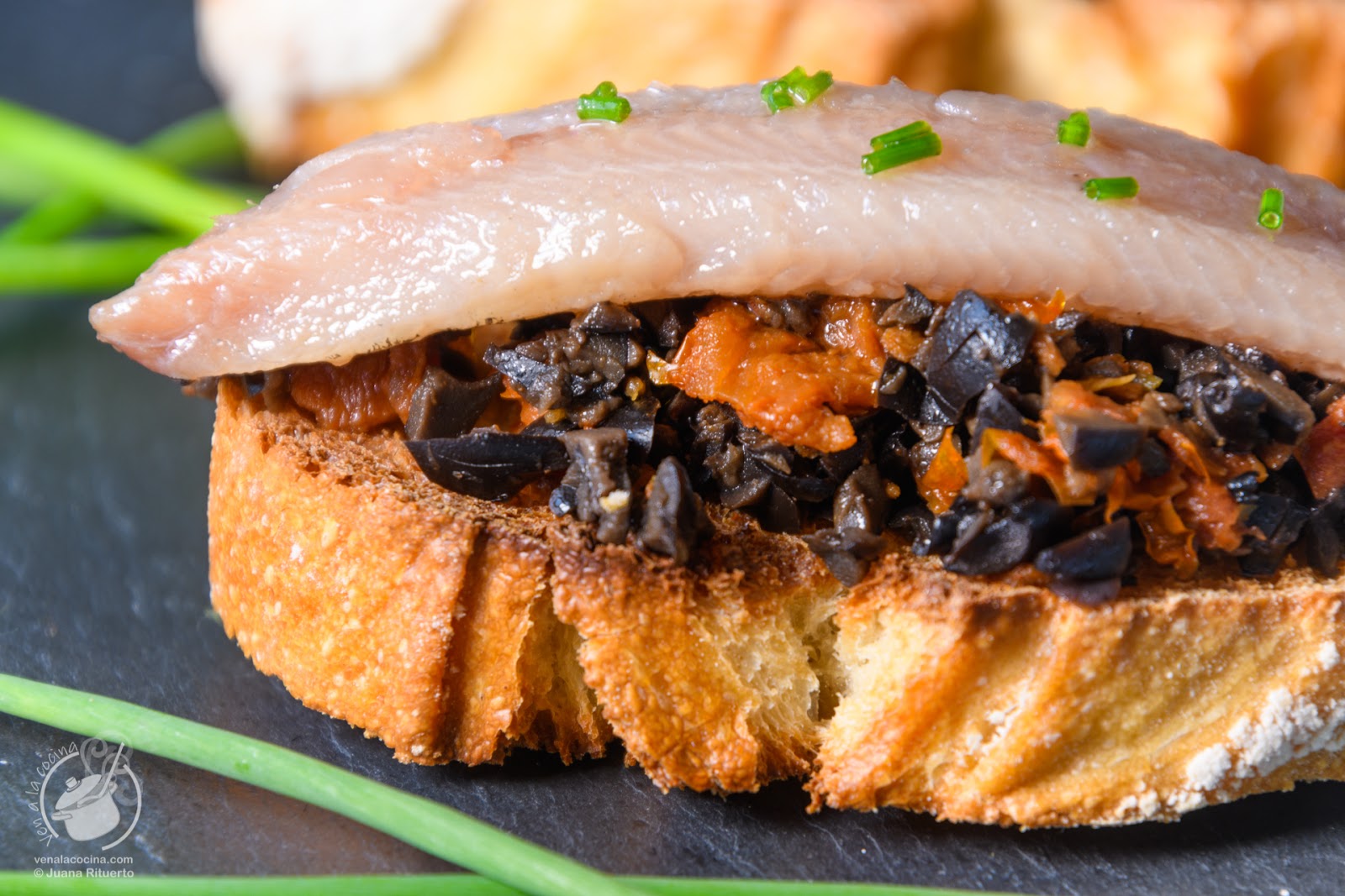 Sardina ahumada sobre brasas de tomate y aceituna negra. Navidad