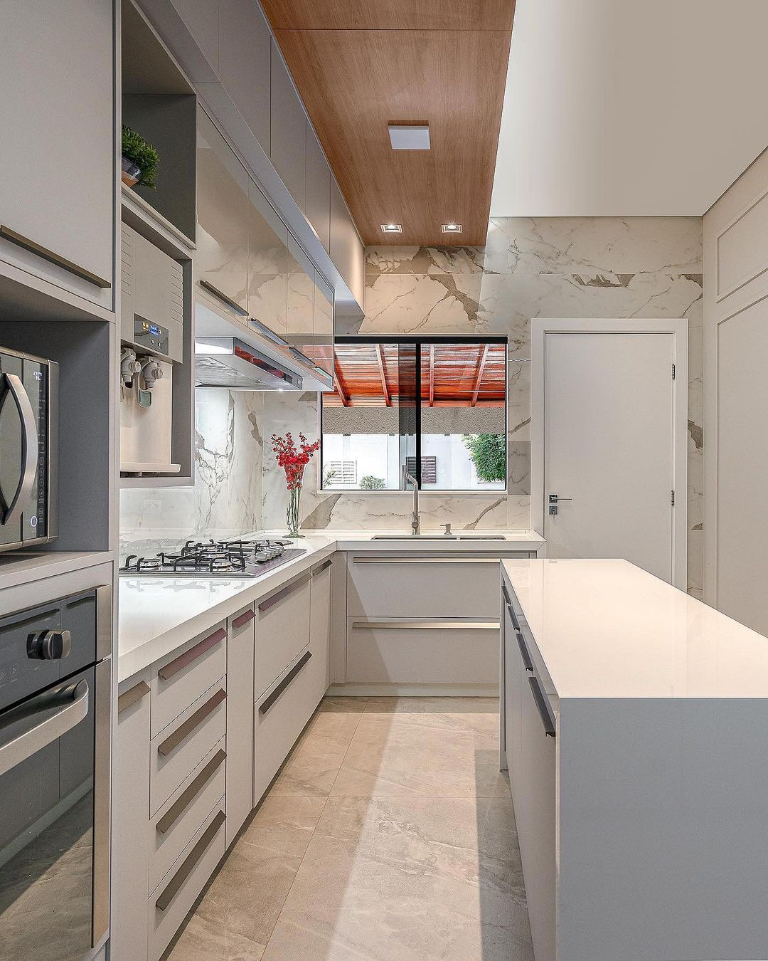 Cozinha retangular com ilha decorada com cores neutras e madeira ...