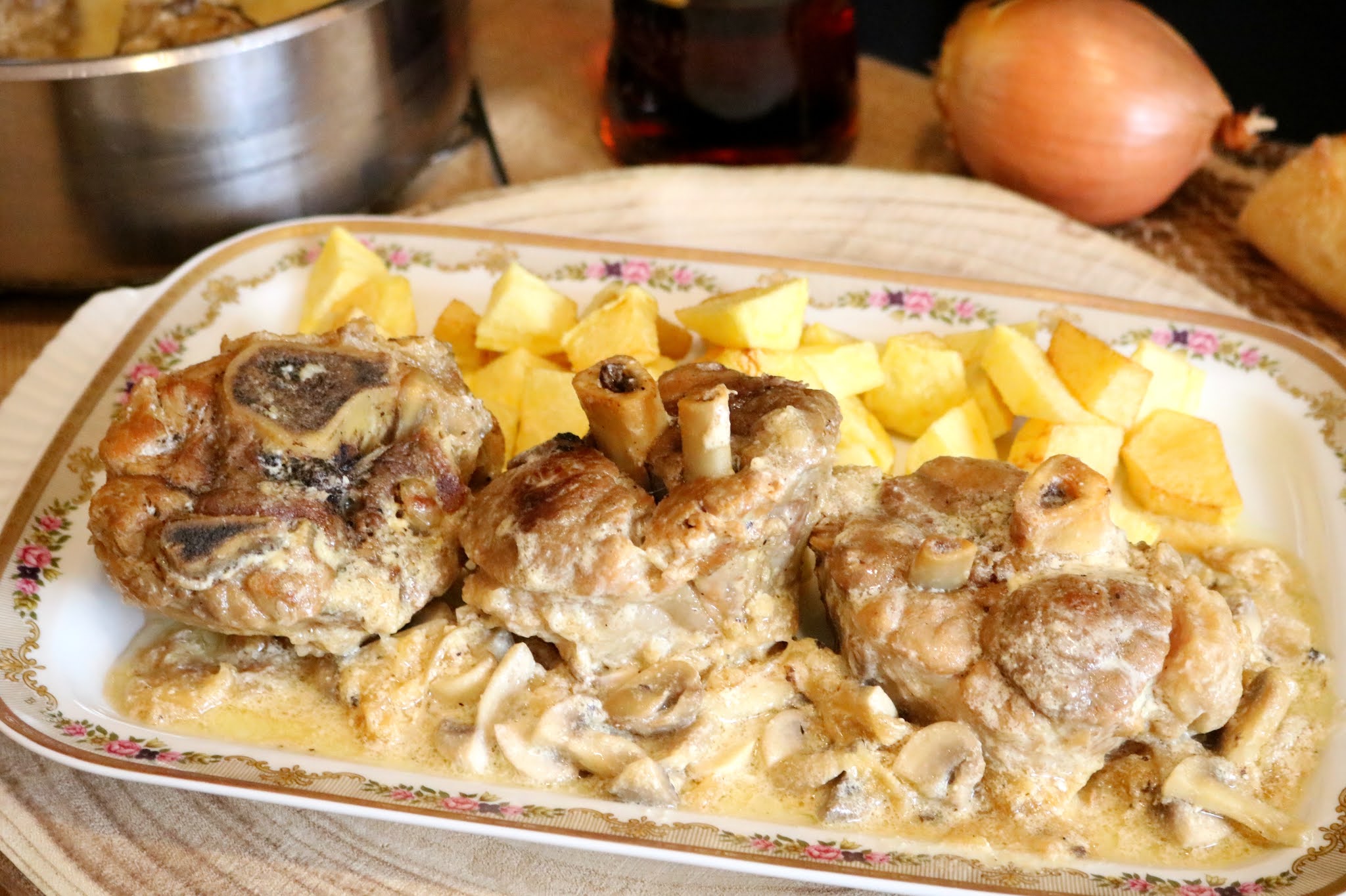 Codillos de cerdo en salsa guisados en cazuela con nata y champiñones ...