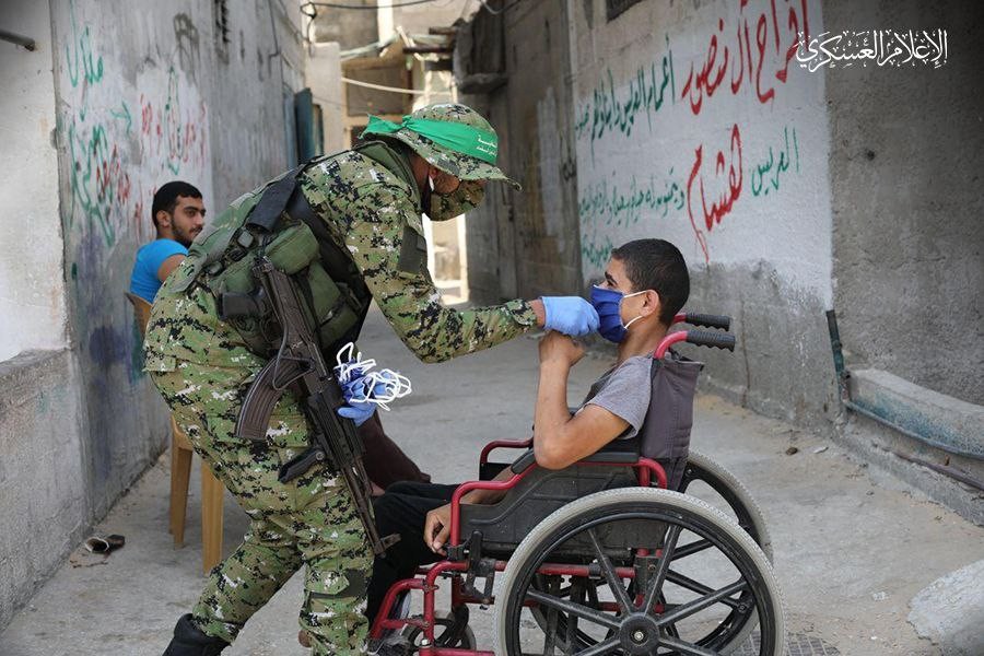 Hamas stages photos of its masked terrorists handing out...masks ...