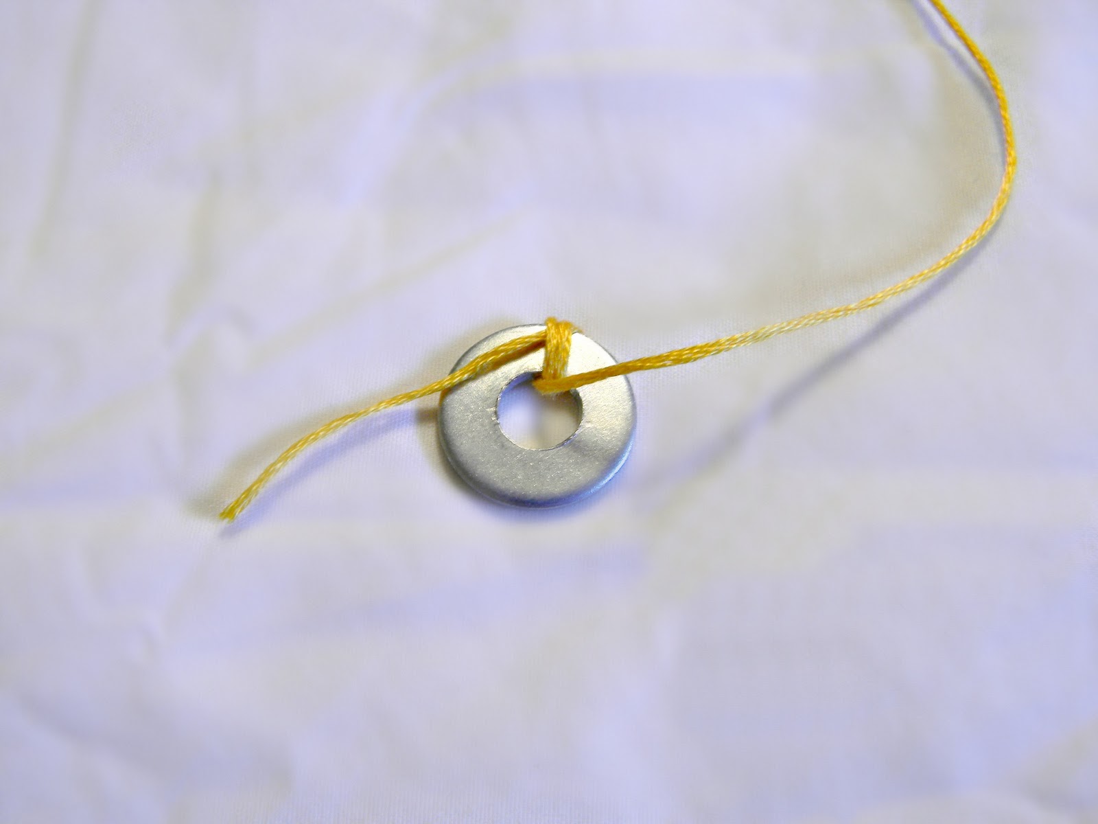 Pull the floss around the washer and through the middle a few more ...