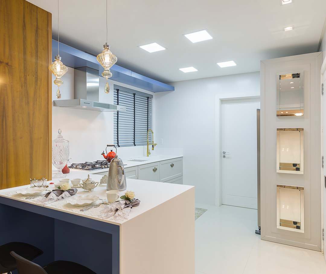 Cozinha azul, branca e amadeirada com bancada em corian e puxadores ...