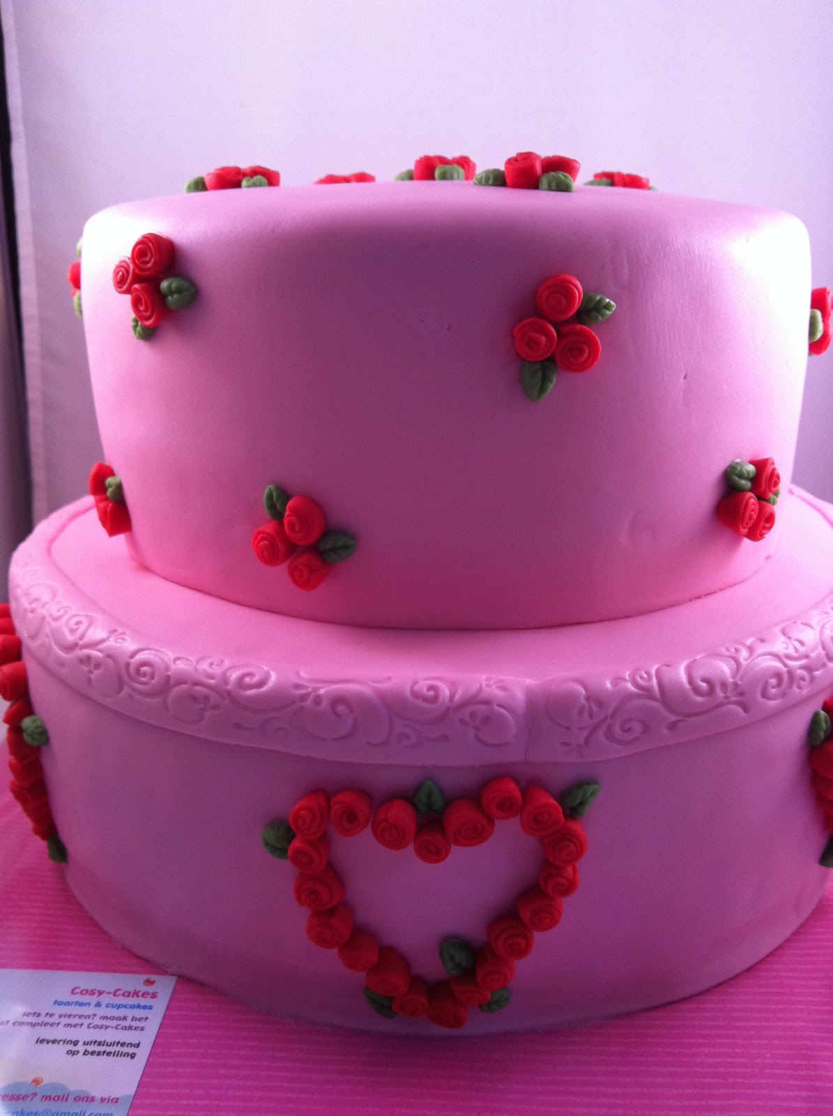 Taart bij Essy's Cosy-Cakes: roze taart met rode rol roosjes