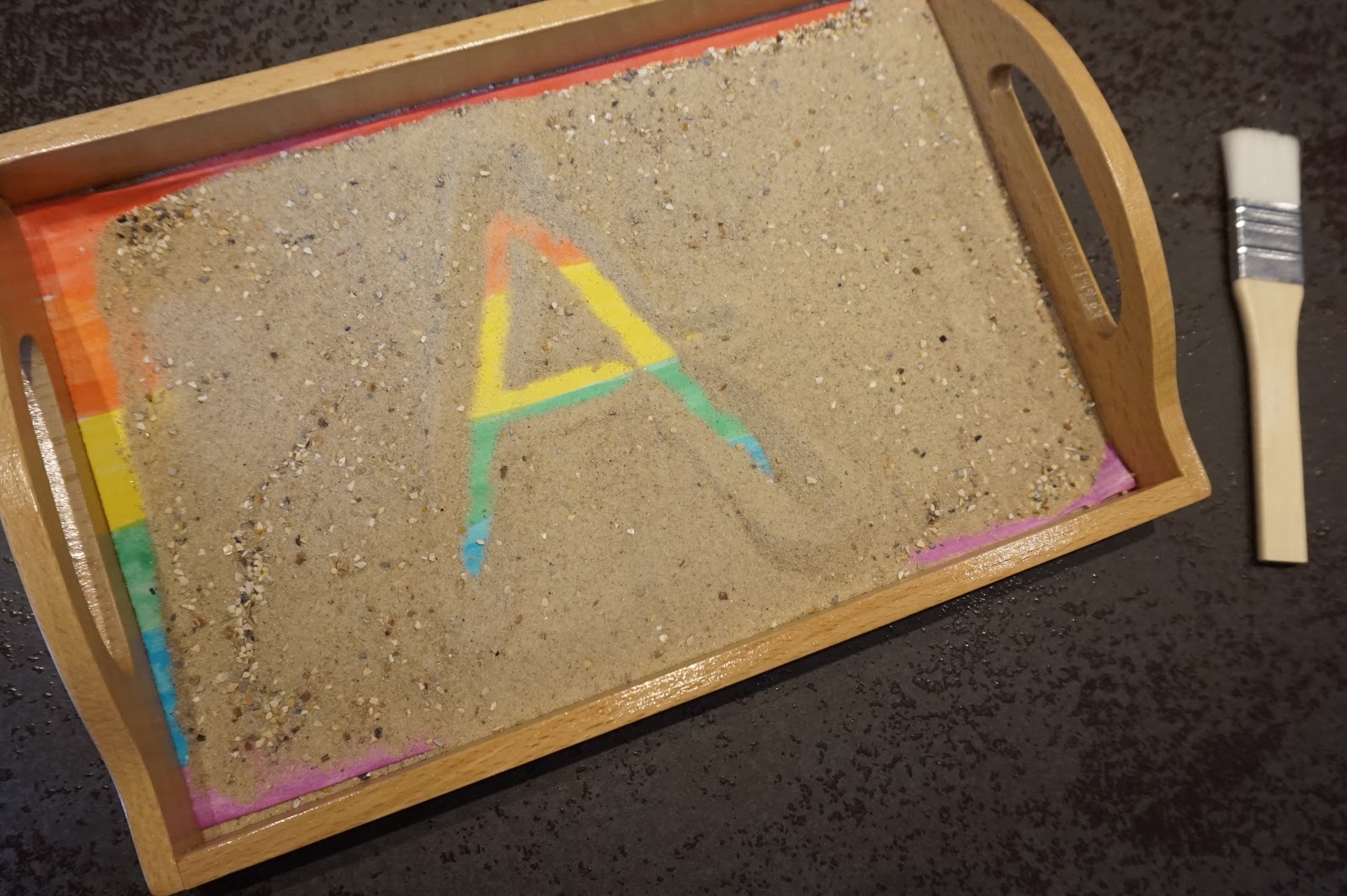 Wir malen einen Regenbogen in Sand