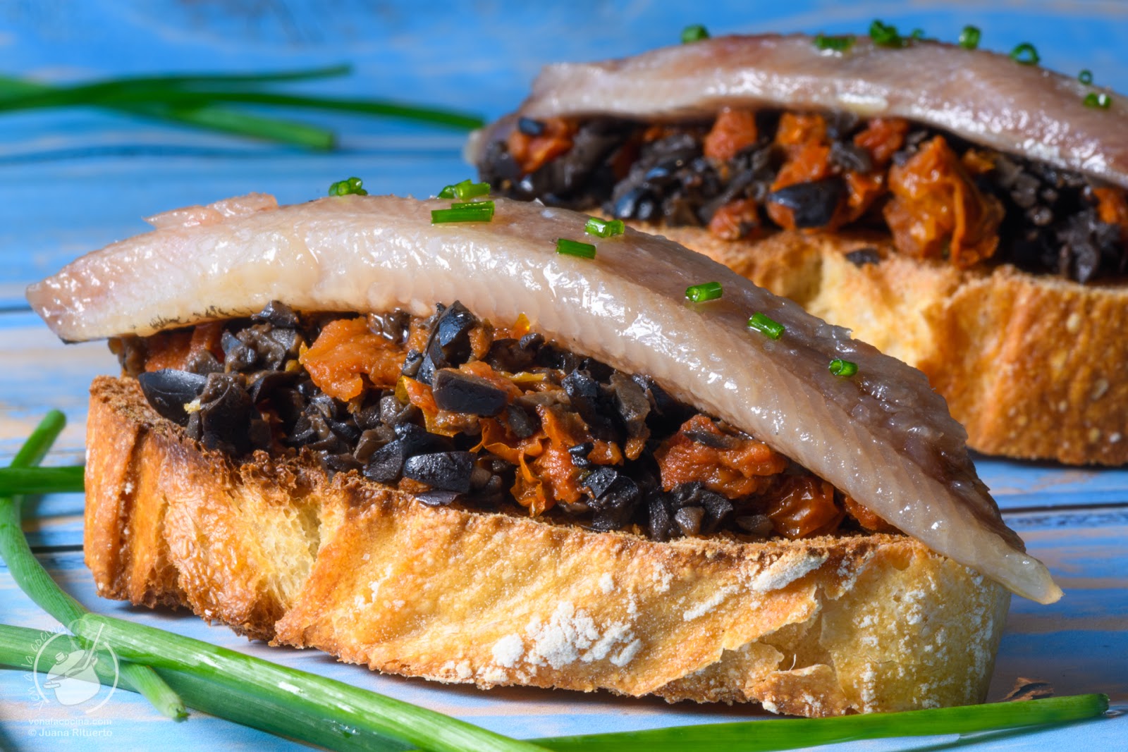 Sardina ahumada sobre brasas de tomate y aceituna negra. Navidad